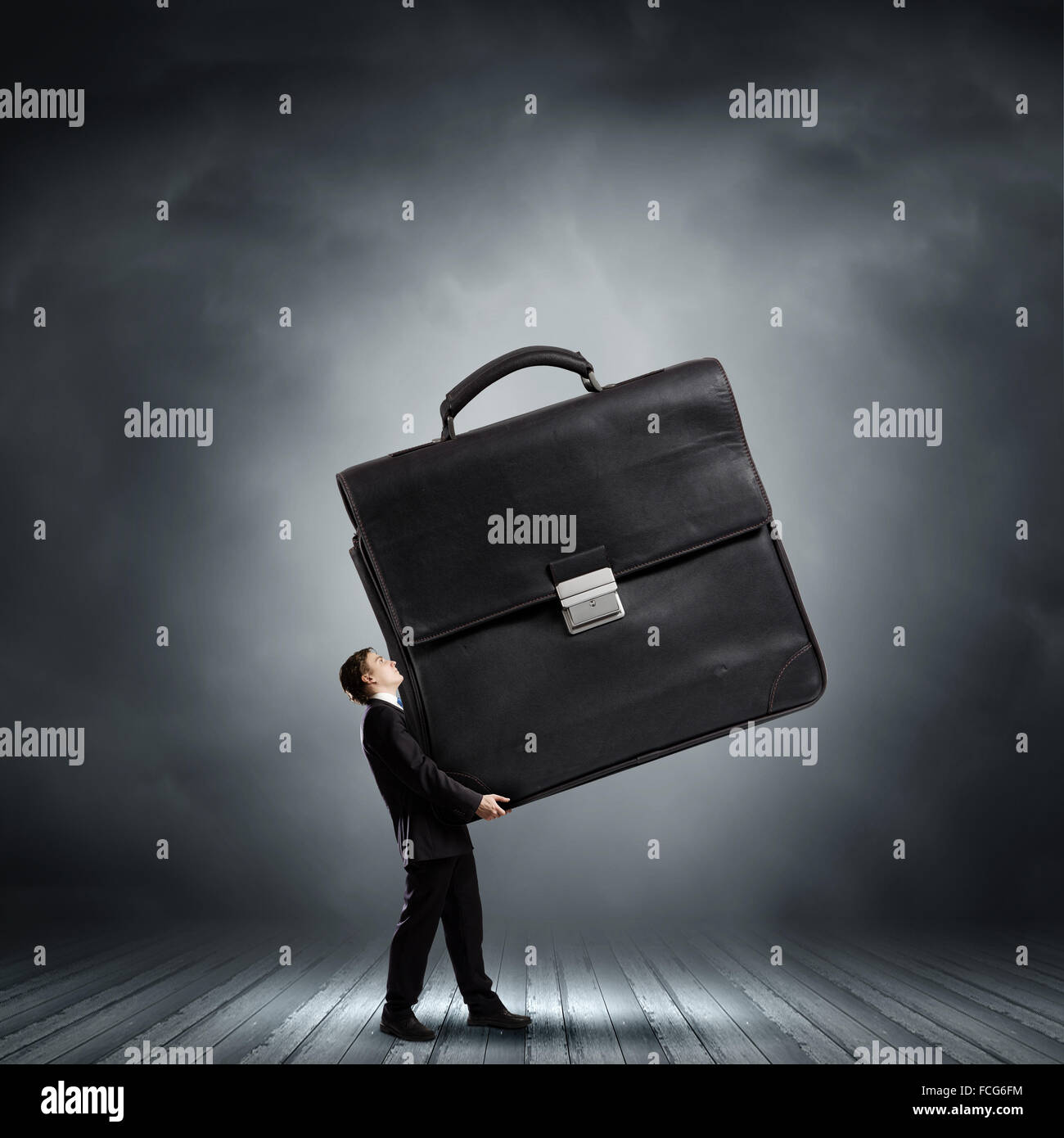 Young determined businessman carrying big heavy suitcase Stock Photo ...
