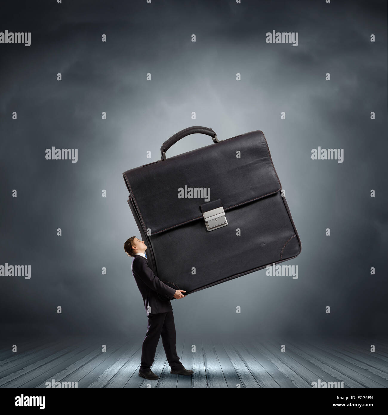 Young determined businessman carrying big heavy suitcase Stock Photo ...