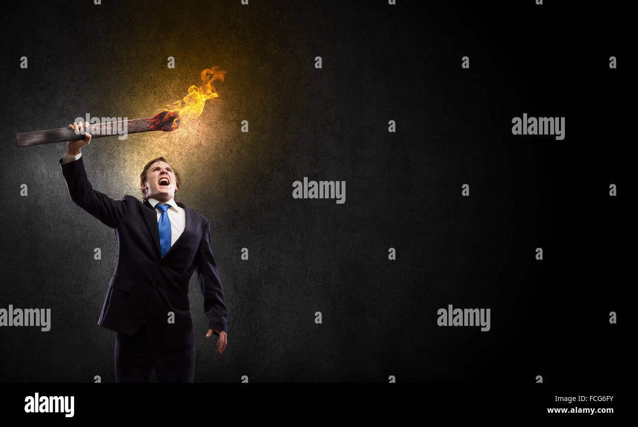 Young businessman holding burning torch in hand Stock Photo - Alamy