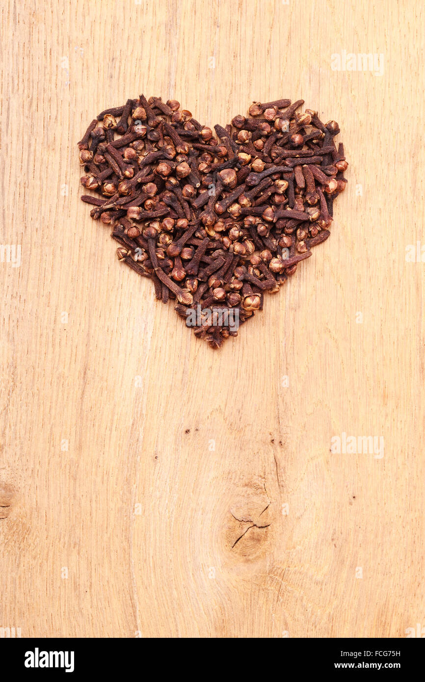 Heart form made from spice cloves on wooden background Stock Photo - Alamy