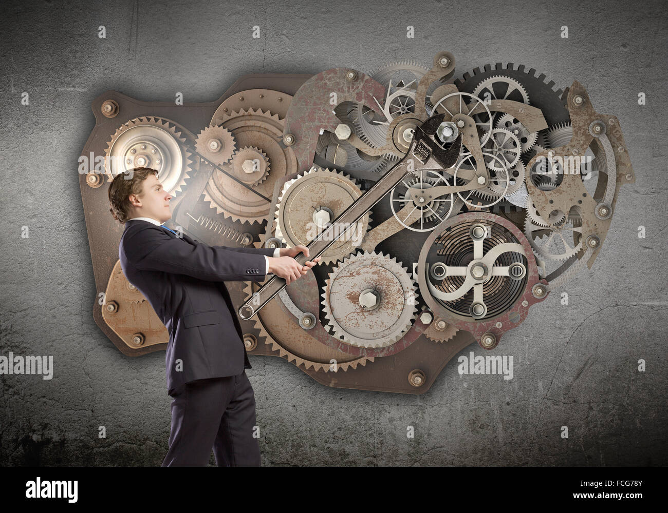 Young businessman fixing gears mechanism with wrench Stock Photo - Alamy