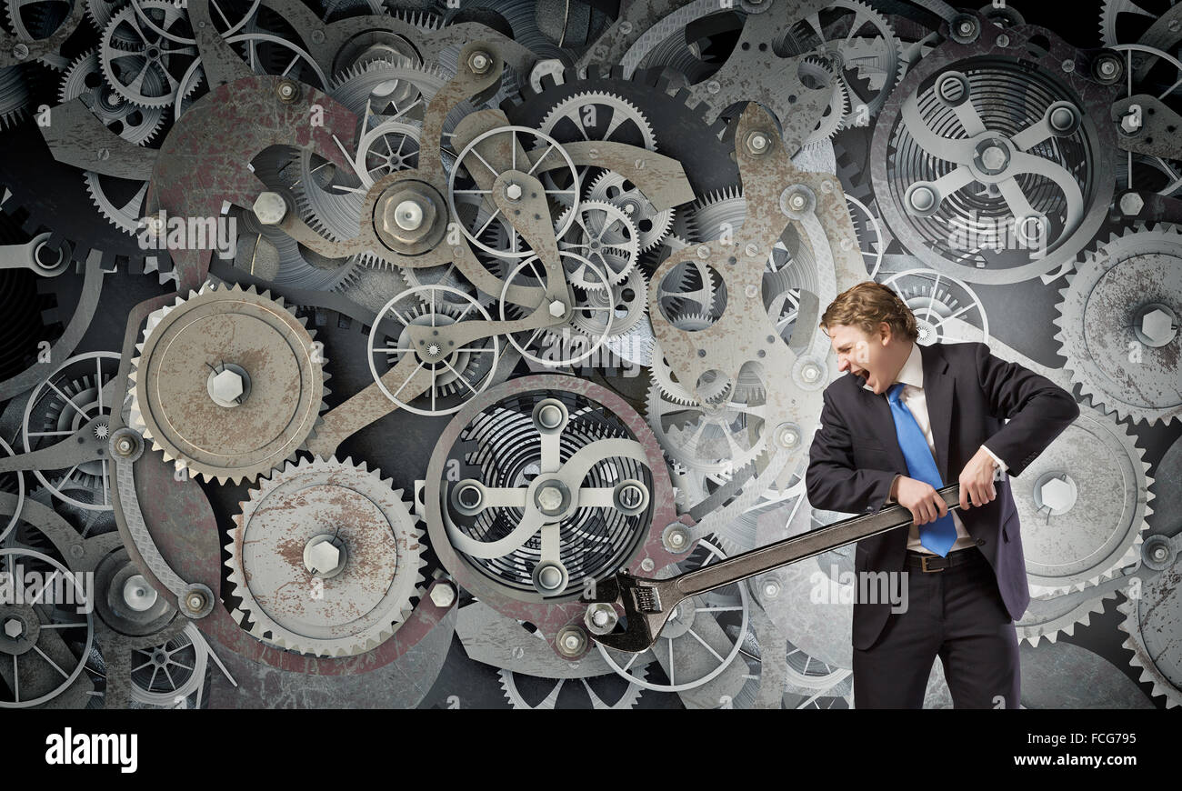 Young businessman fixing gears mechanism with wrench Stock Photo - Alamy