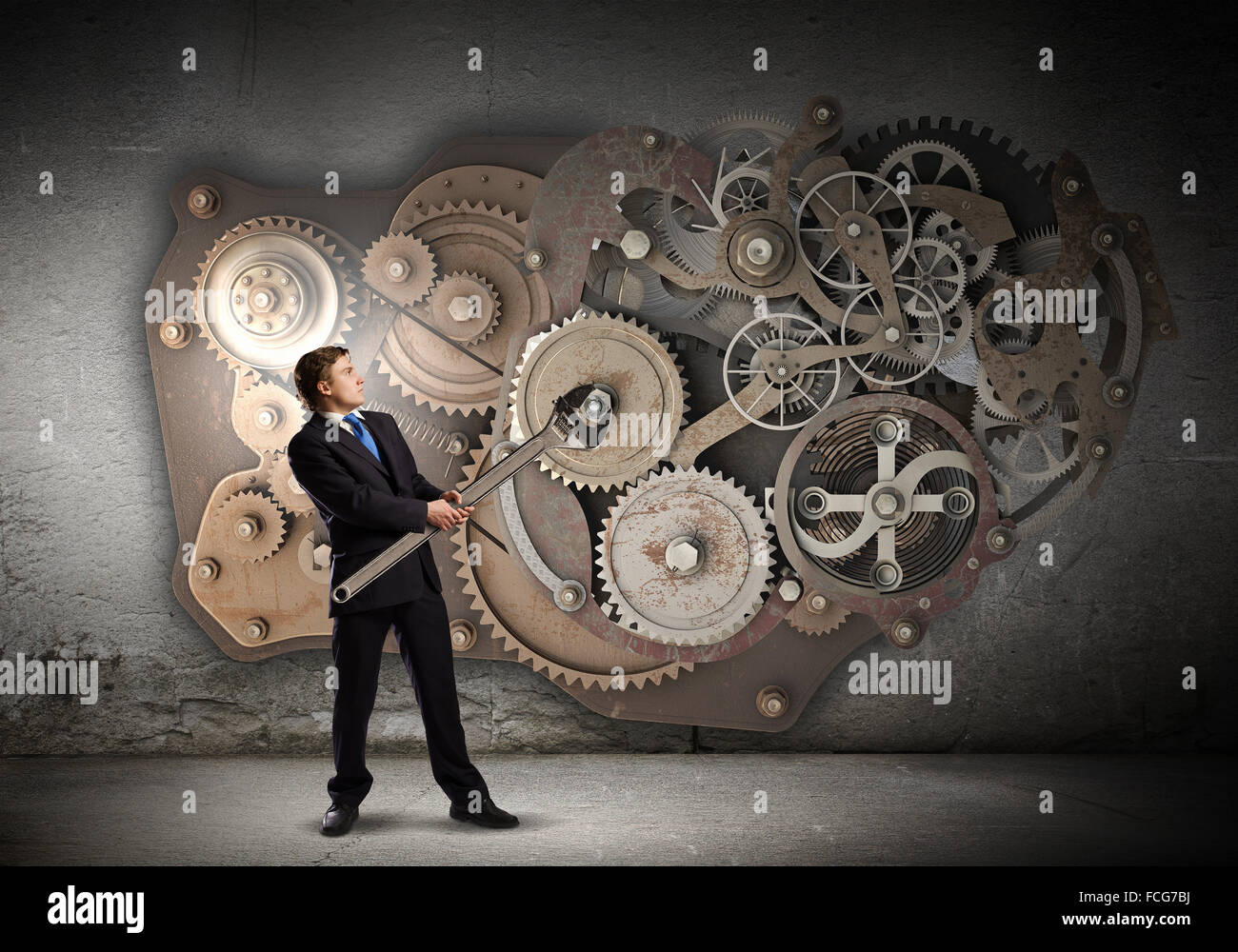 Young businessman fixing gears mechanism with wrench Stock Photo - Alamy