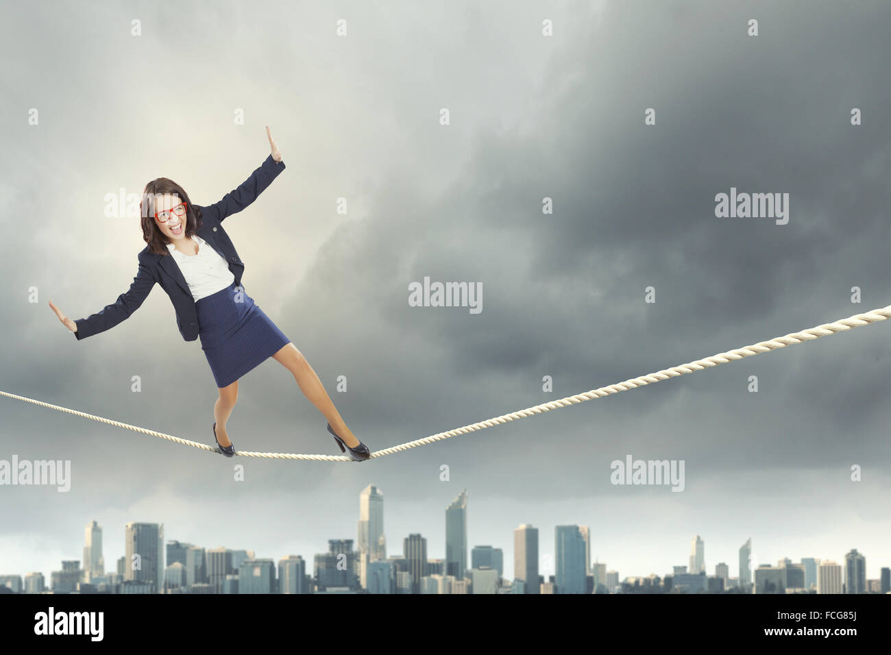 Young businesswoman balancing on rope above city Stock Photo - Alamy