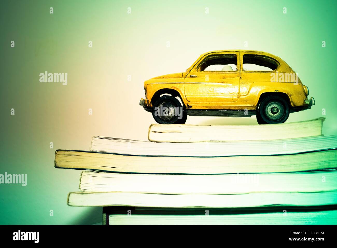 Miniature car brand Mini yellow on a stack of books Stock Photo - Alamy
