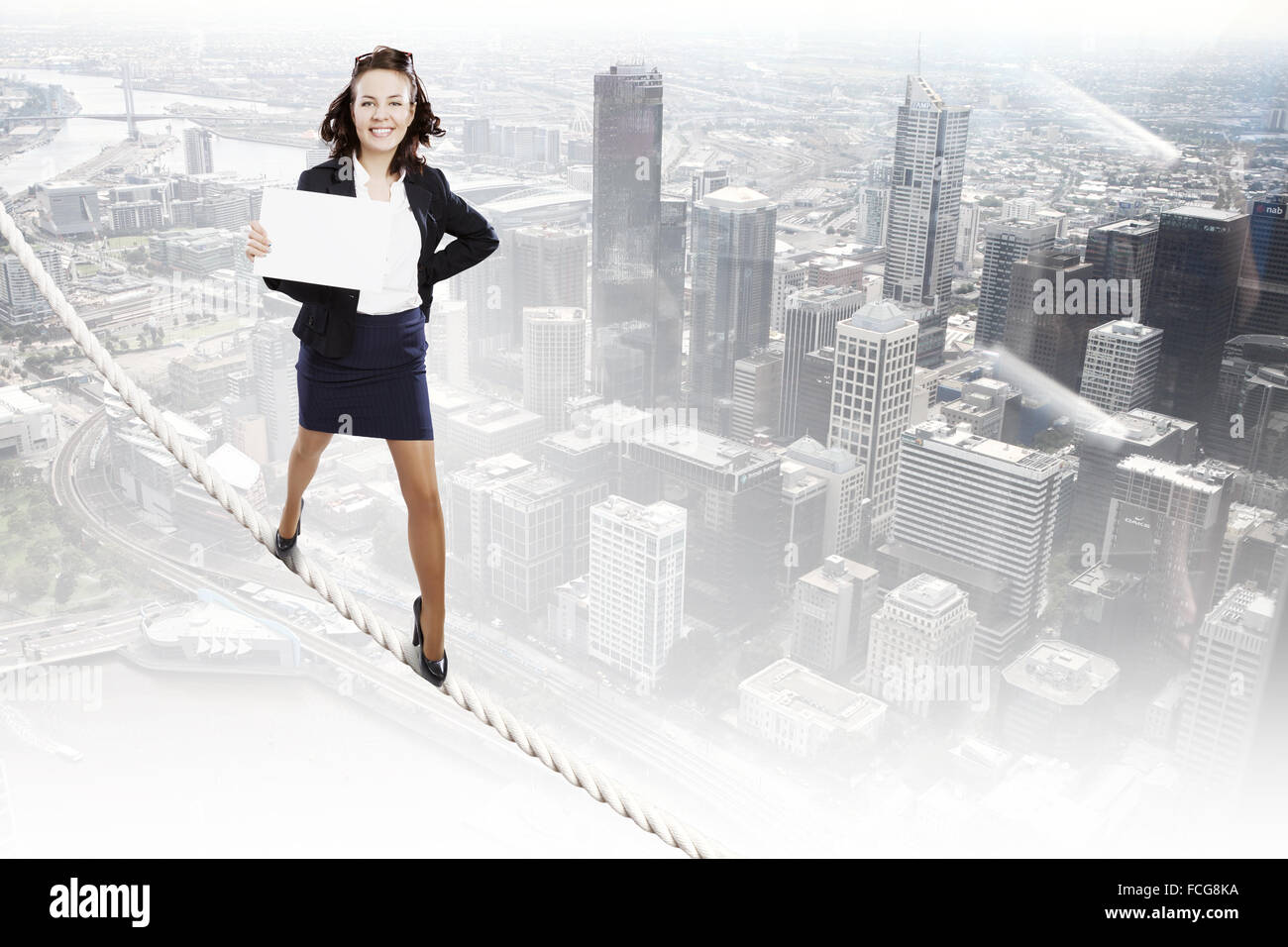 Young businesswoman walking on rope with blank banner Stock Photo - Alamy