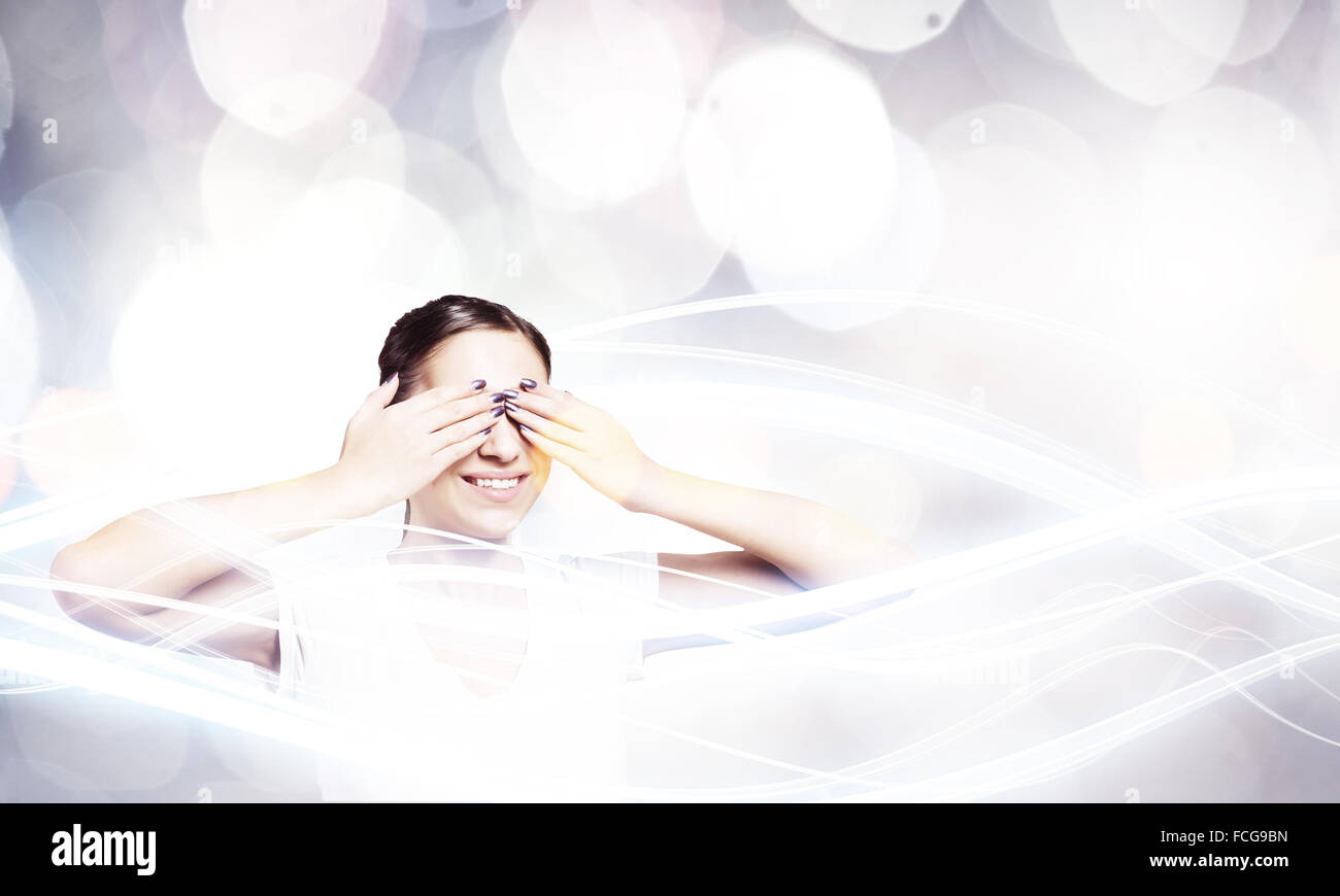 Young woman in casual hiding eyes behind palms Stock Photo - Alamy