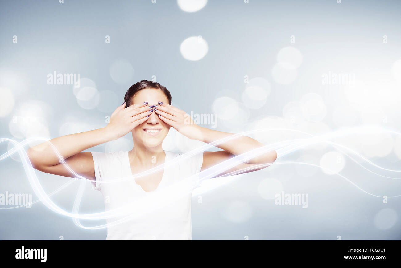 Young woman in casual hiding eyes behind palms Stock Photo - Alamy