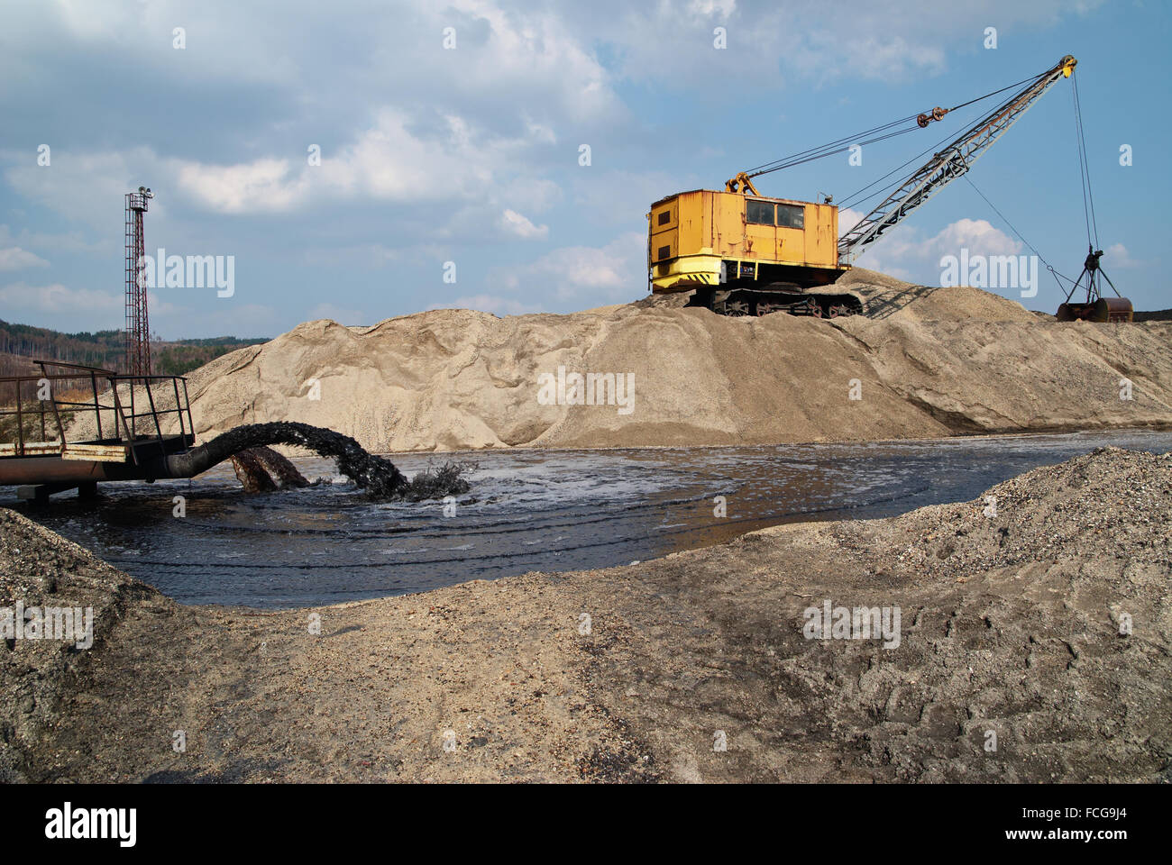 Rope excavator for mining sludge among piles of sand, black sludge ...