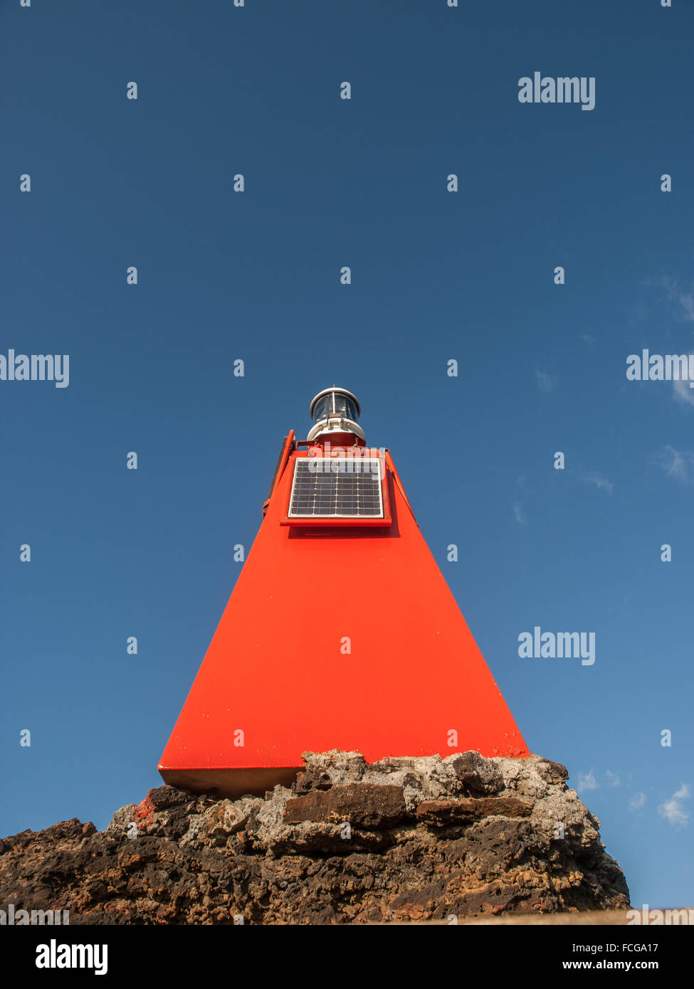 Bright red orange small triangle shaped lighthouse at the top of the ...