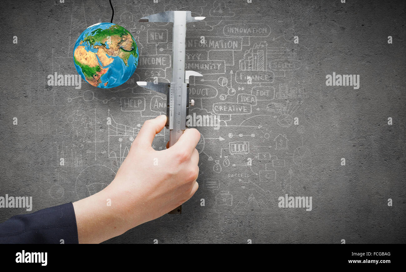 Close up of business person hand measuring Earth planet. Elements of ...