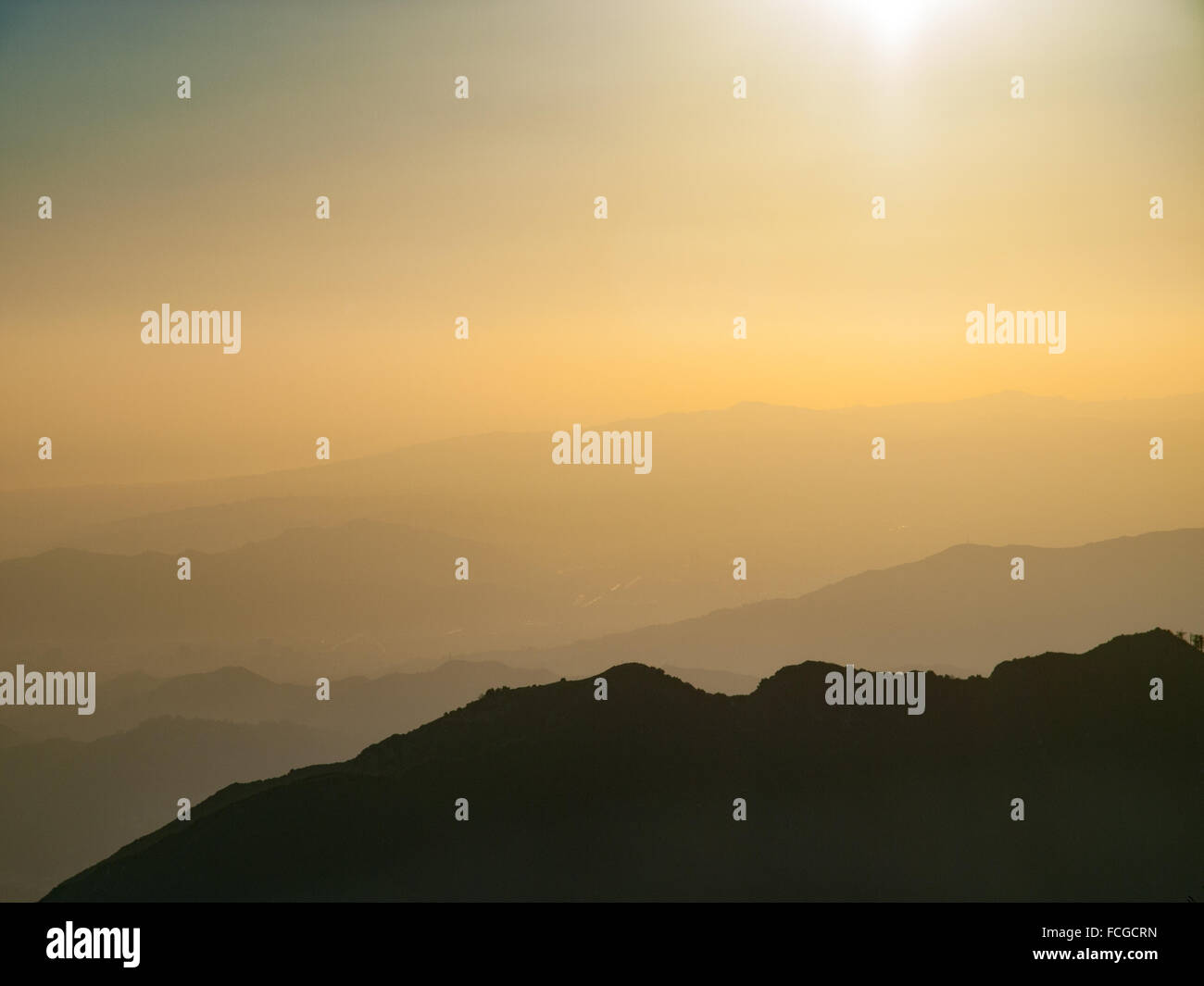 Orange and yellow hazy sunset over mountains in California, USA Stock ...
