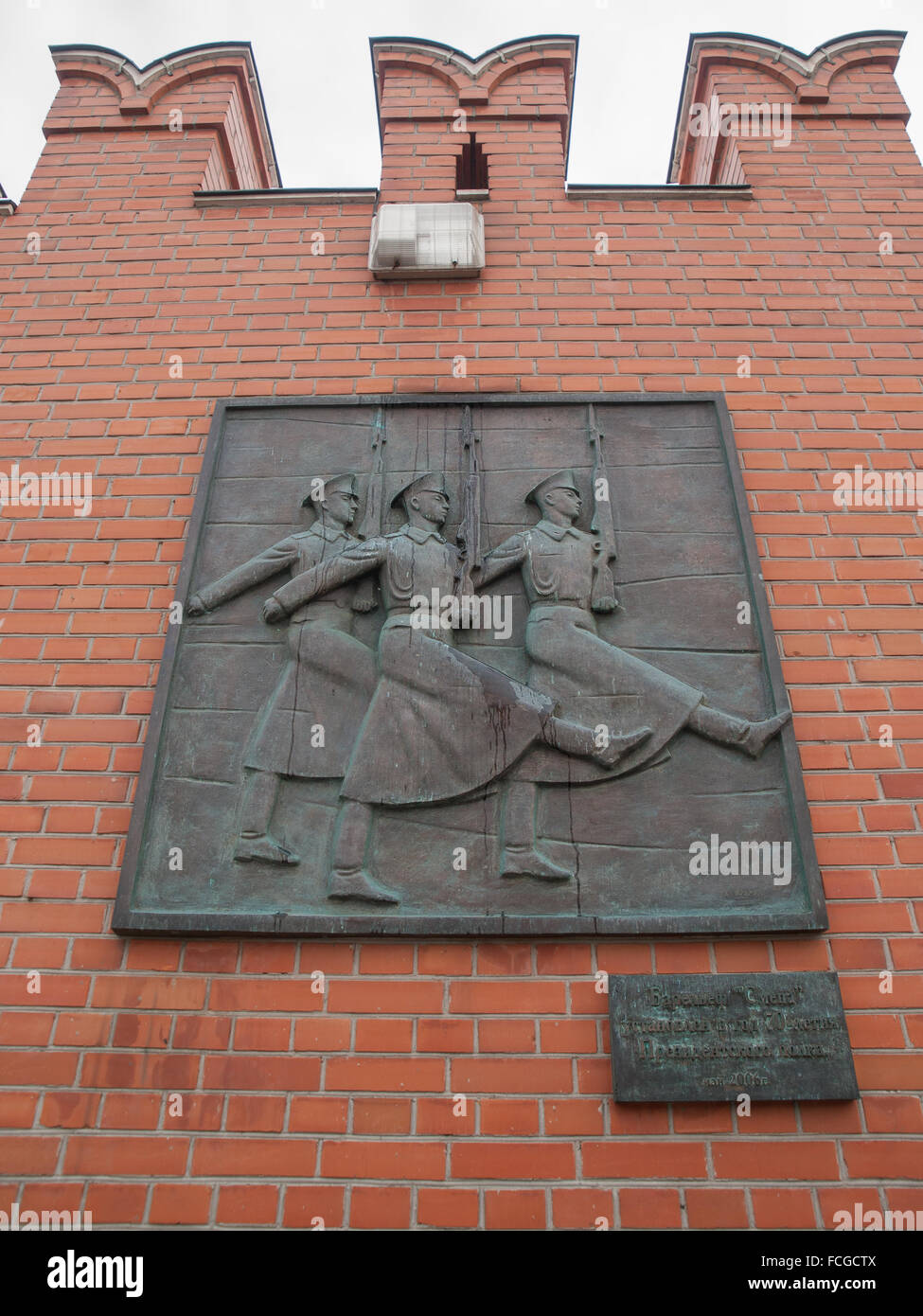 Plaque of three marching soldiers with guns on red brick wall outside ...