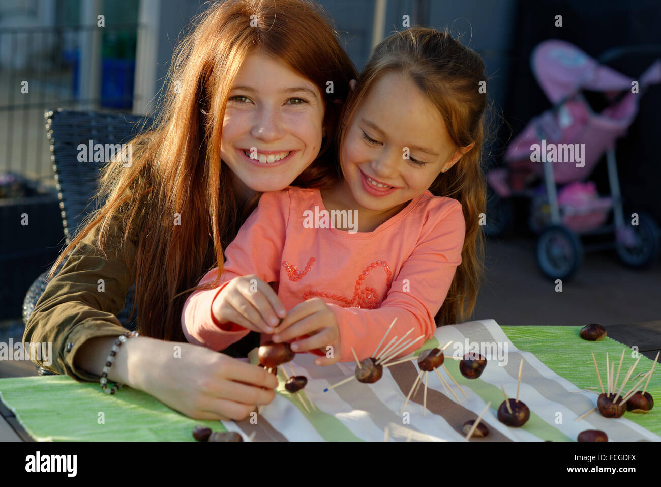 Portrait of two sisters tinkering chestnut figurines Stock Photo - Alamy