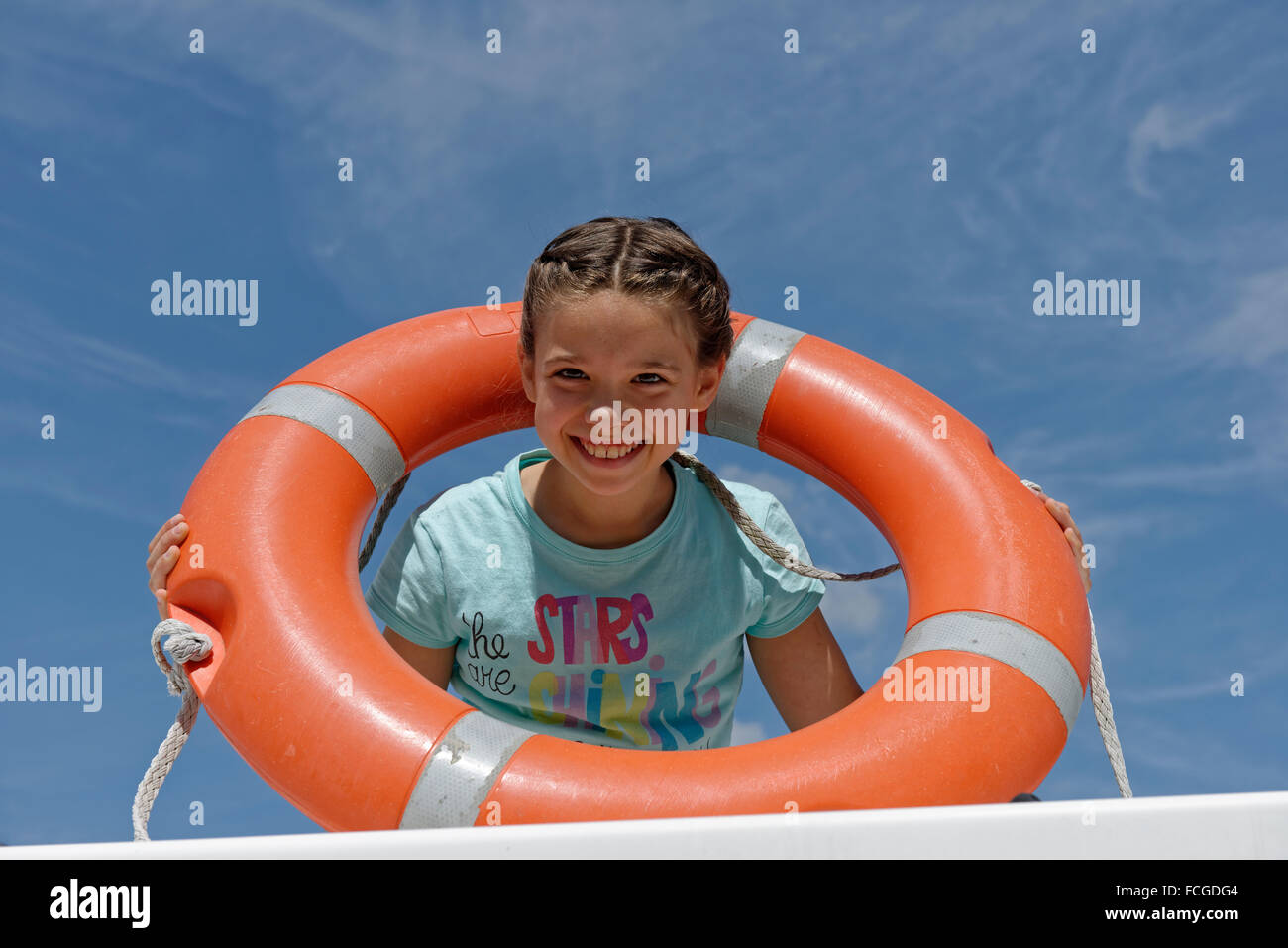 Portrait of smiling girl lifesaver in front of sky Stock Photo - Alamy