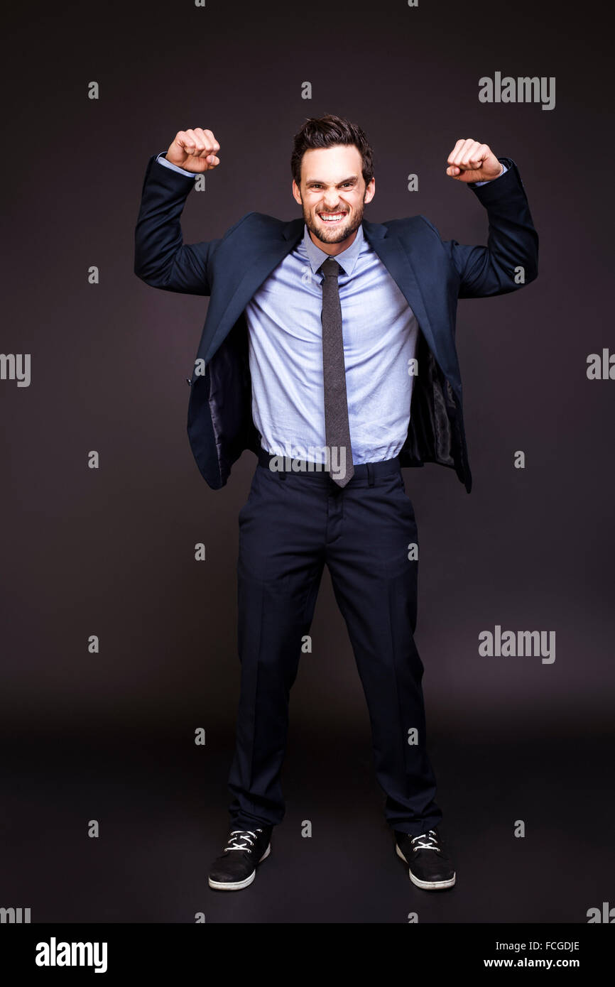 Young man in suit flexing his muscles Stock Photo - Alamy