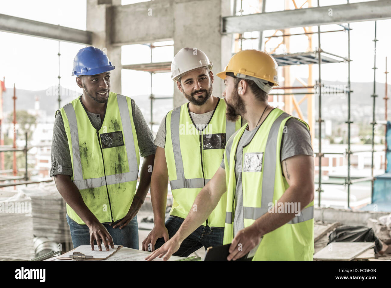 Construction workers discussing in construction site Stock Photo - Alamy
