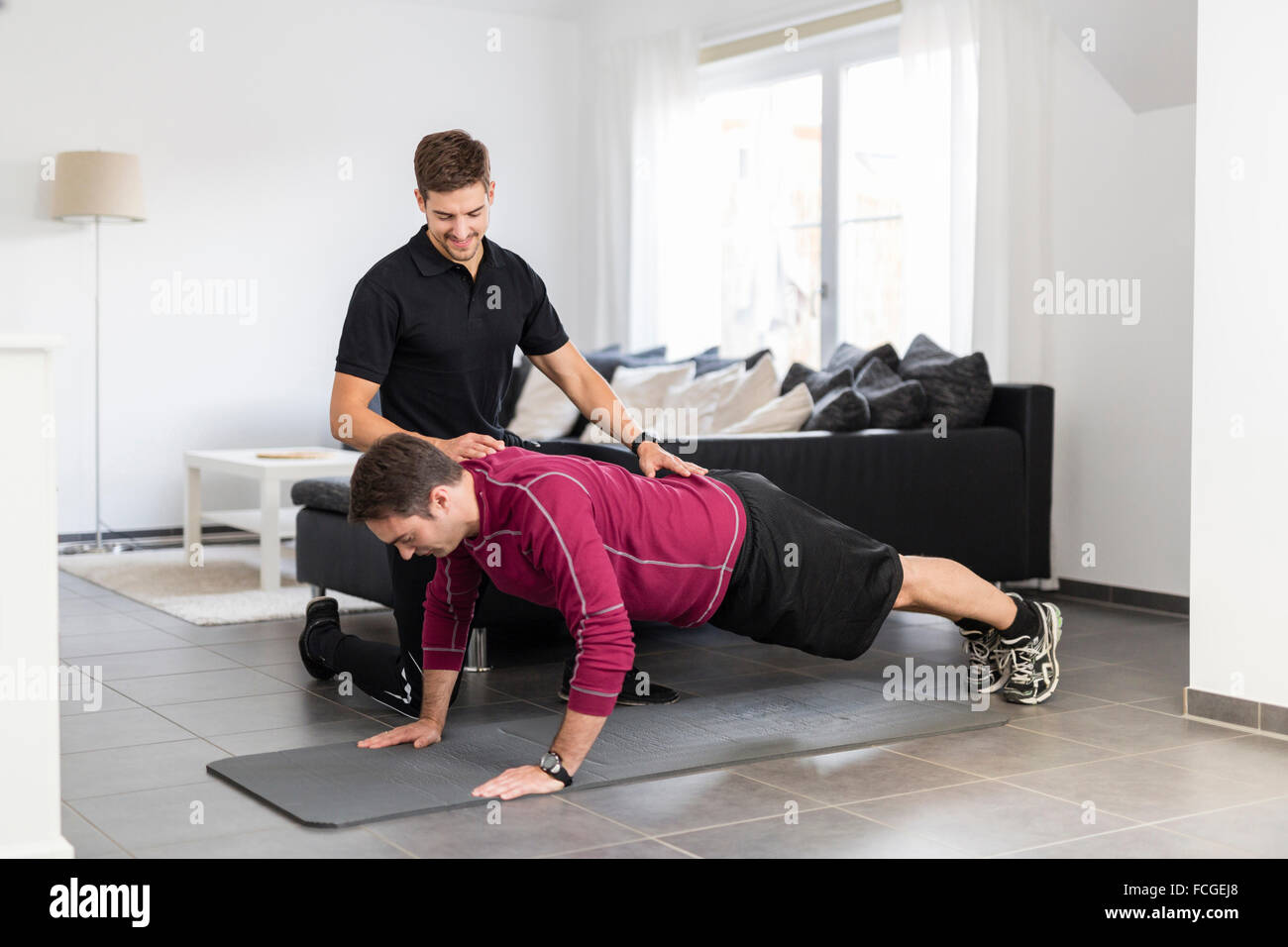 Coach doing exercises man at home Stock Photo - Alamy
