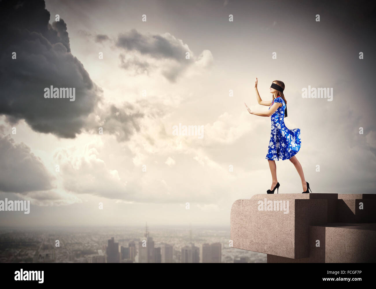 Young woman in blue dress walking on edge of roof Stock Photo - Alamy