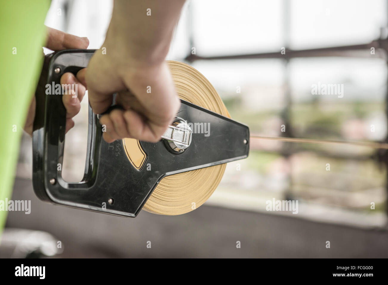Close-up of construction worker using tape measure in construction site ...