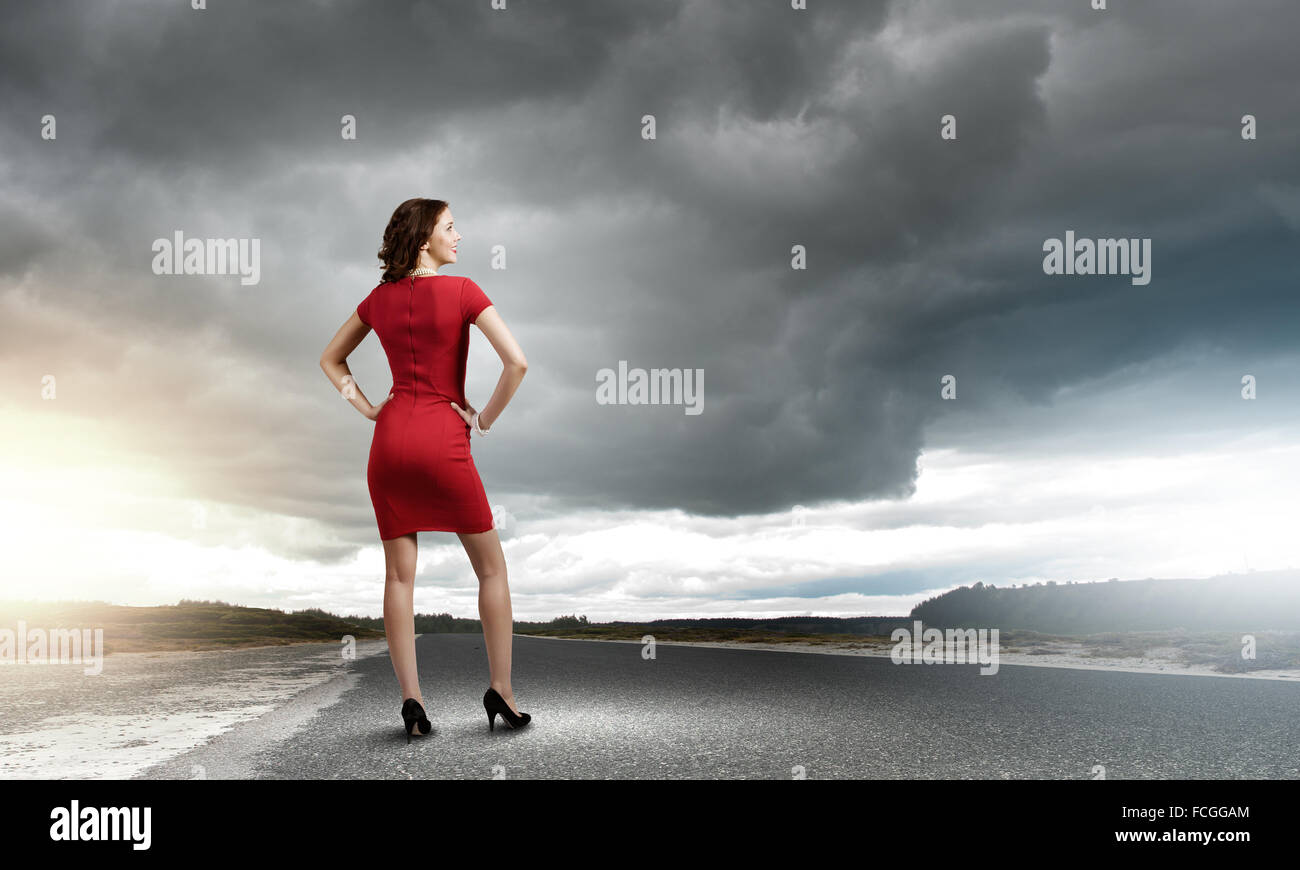 Rear view of young woman standing aside of road Stock Photo - Alamy