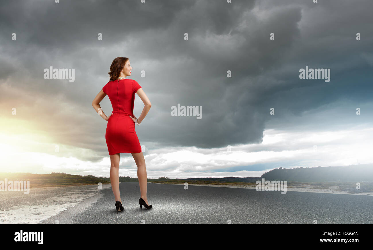 Rear view of young woman standing aside of road Stock Photo - Alamy