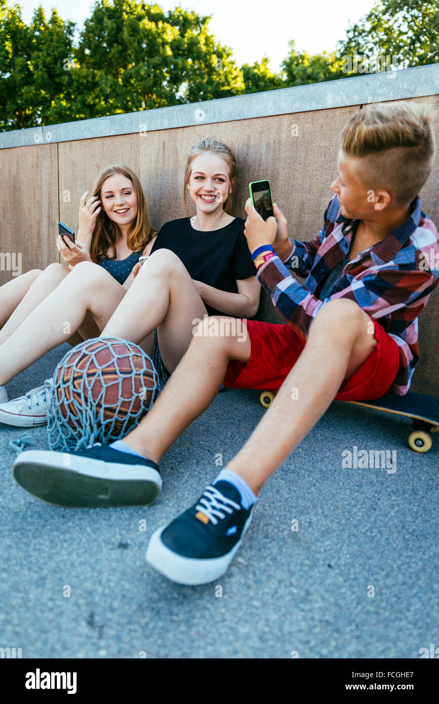 Teenage boy taking cell phone picture of friends outdoors Stock Photo ...