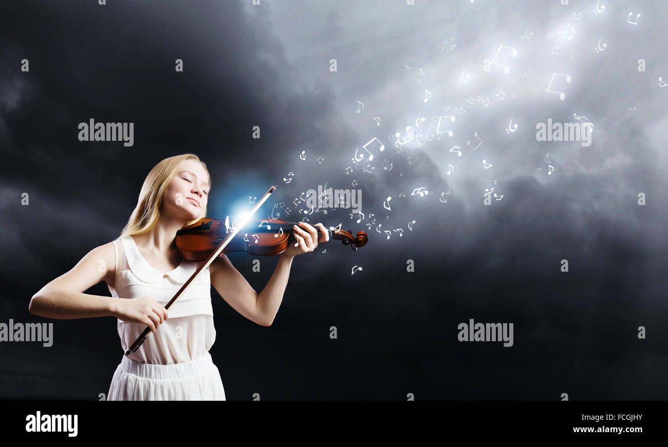 Young woman in white dress playing violin at night Stock Photo - Alamy