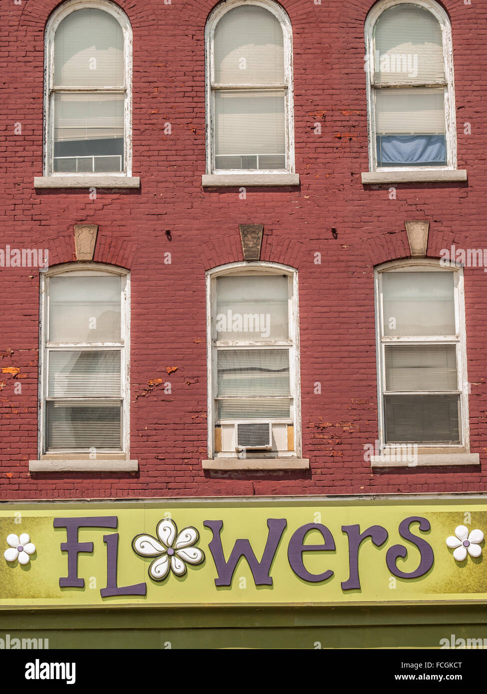 Green and purple Flower retail store sign below apartment windows on ...