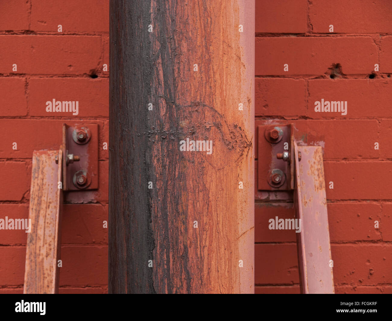Rusted metal post against painted red brick wall in downtown Montreal ...