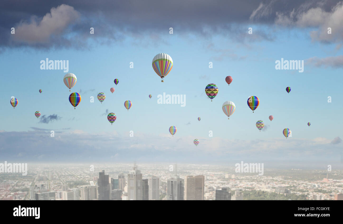 Colorful aerostats flying in clear sky above modern city Stock Photo ...