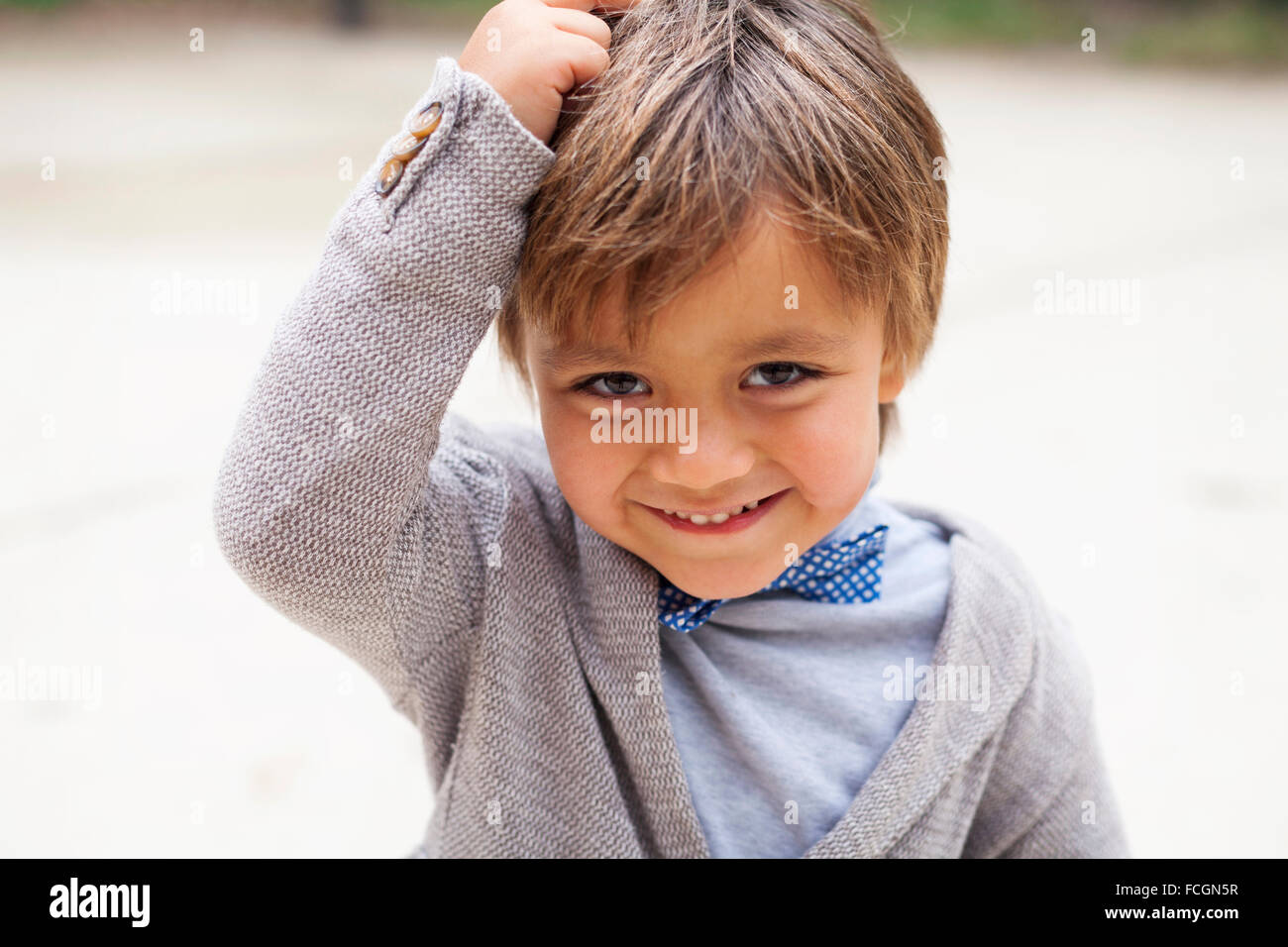 Portrait of smiling little boy hand on his head Stock Photo - Alamy