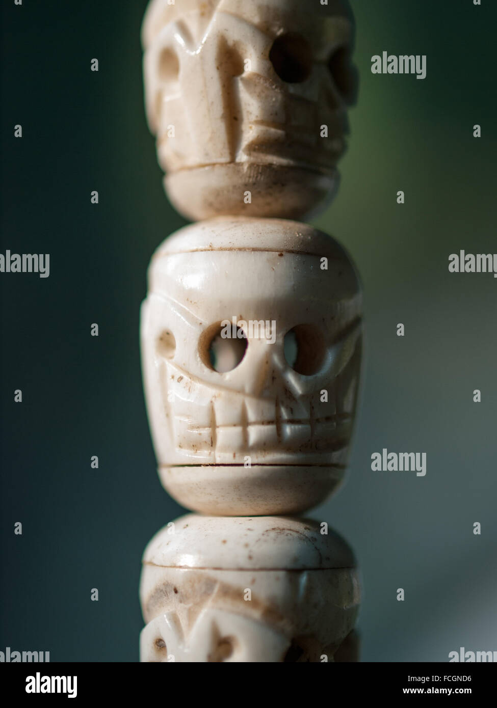 Primitive carving of three human skeletons hanging on string Stock ...