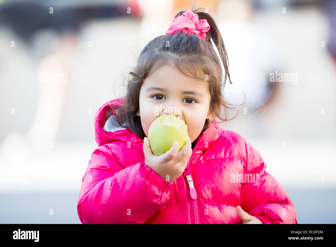 Portrait of little girl eating an apple Stock Photo - Alamy
