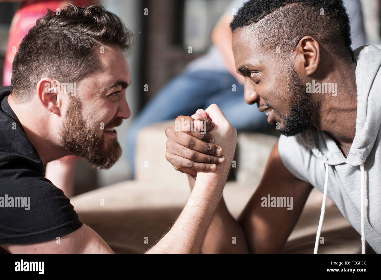 Friends together having a good time arm wrestling Stock Photo - Alamy