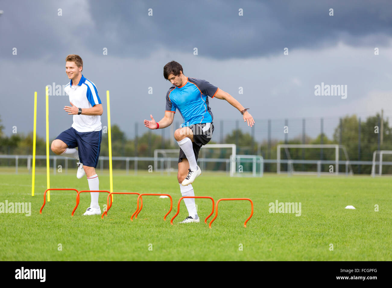Two soccer players exercising on sports field Stock Photo - Alamy