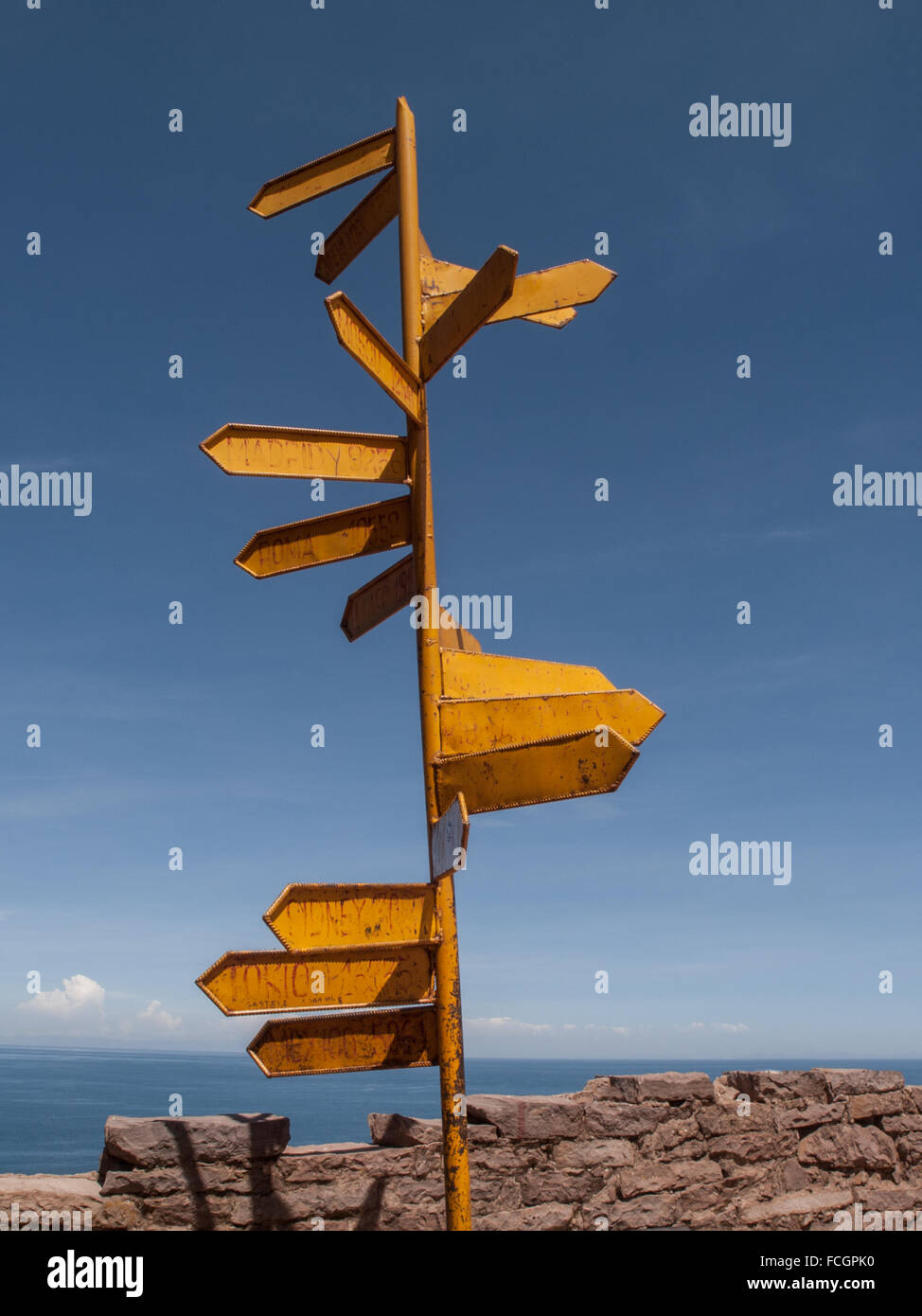 Yellow pole and directional signs with faded writing in Peru, South ...