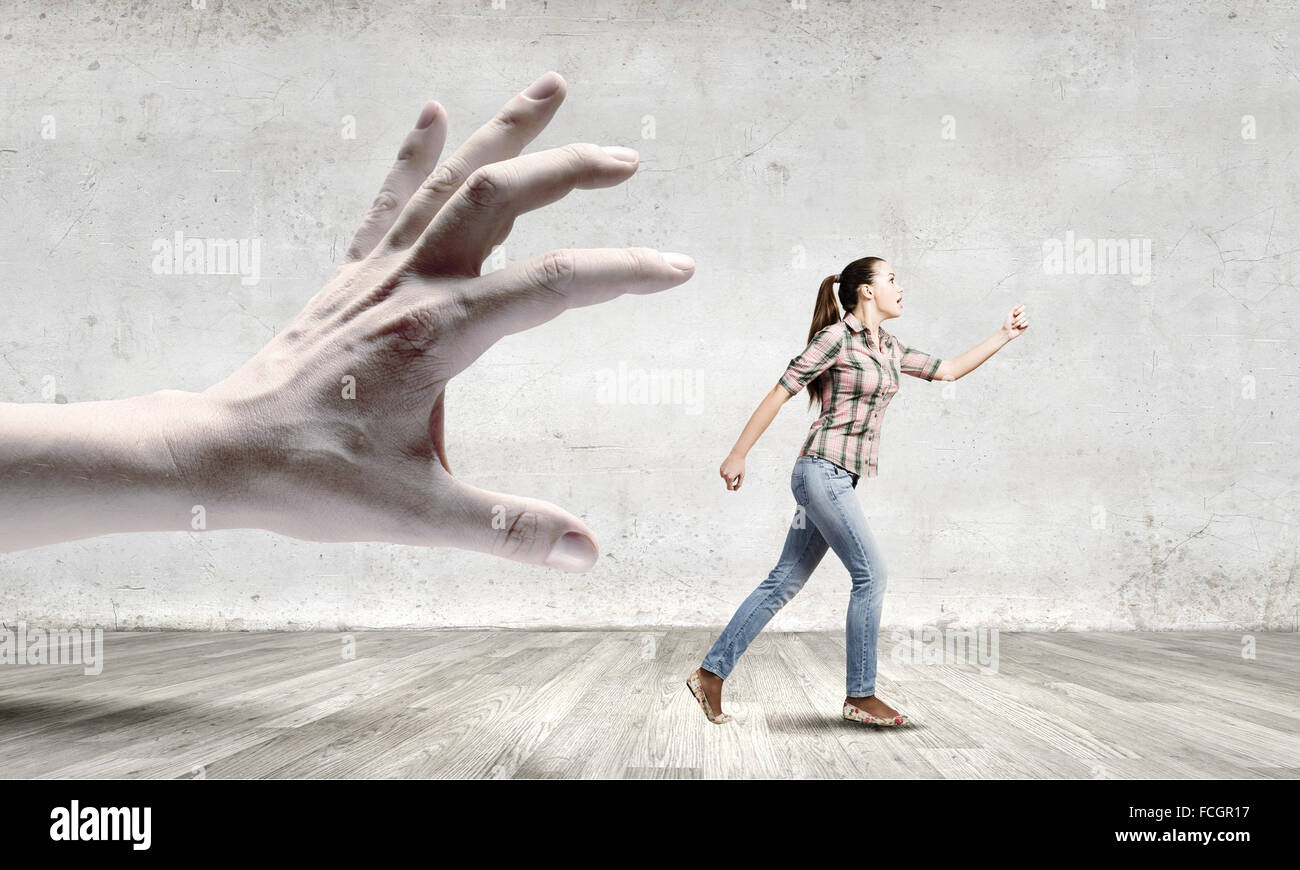 Young woman in casual escaping from big male hand Stock Photo - Alamy