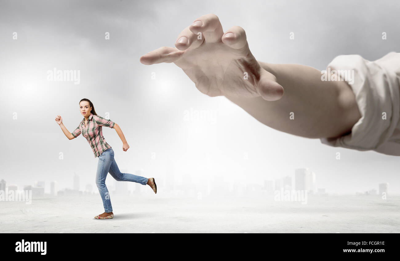 Young woman in casual escaping from big male hand Stock Photo - Alamy