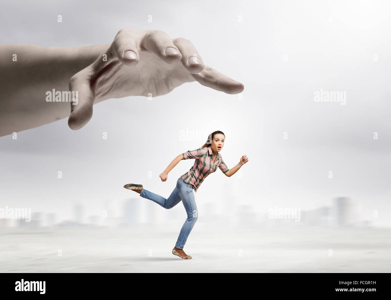 Young woman in casual escaping from big male hand Stock Photo - Alamy
