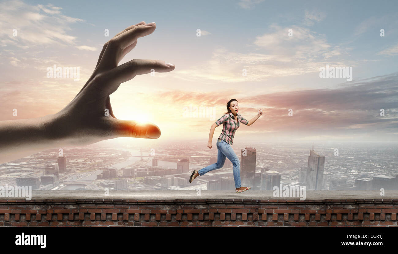 Young woman in casual escaping from big male hand Stock Photo - Alamy