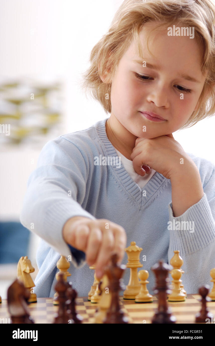 Portrait of little boy playing chess Stock Photo - Alamy