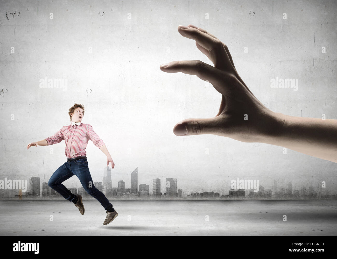 Young man trying to run away from big male hand Stock Photo - Alamy