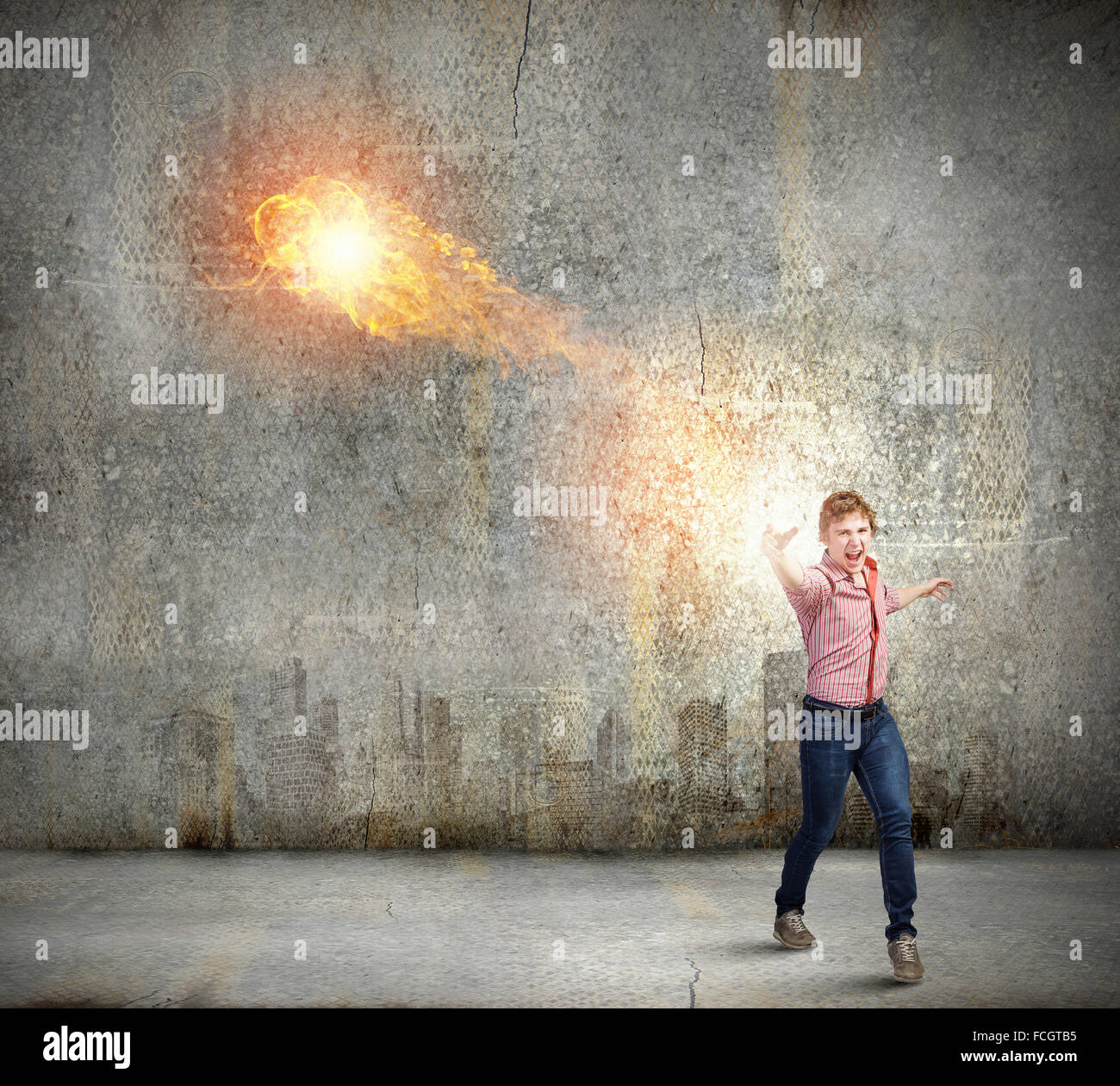 Young man in casual throwing fire ball Stock Photo - Alamy