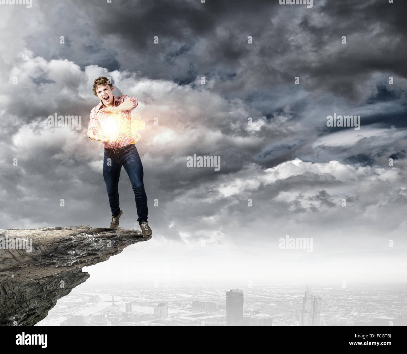 Young man in casual throwing fire ball Stock Photo - Alamy