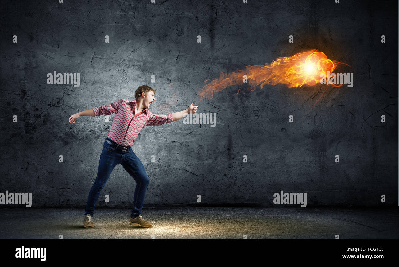 Young man in casual throwing fire ball Stock Photo - Alamy