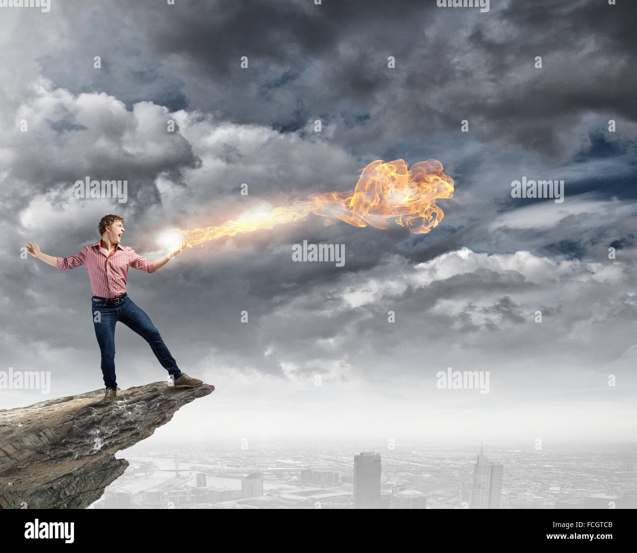 Young man in casual throwing fire ball Stock Photo - Alamy