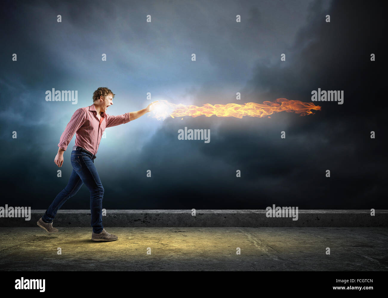 Young man in casual throwing fire ball Stock Photo - Alamy