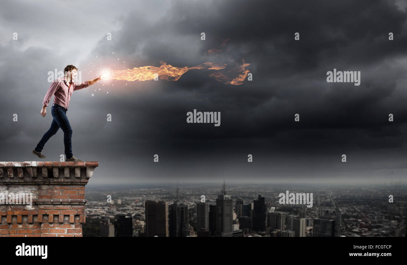Young man in casual throwing fire ball Stock Photo - Alamy