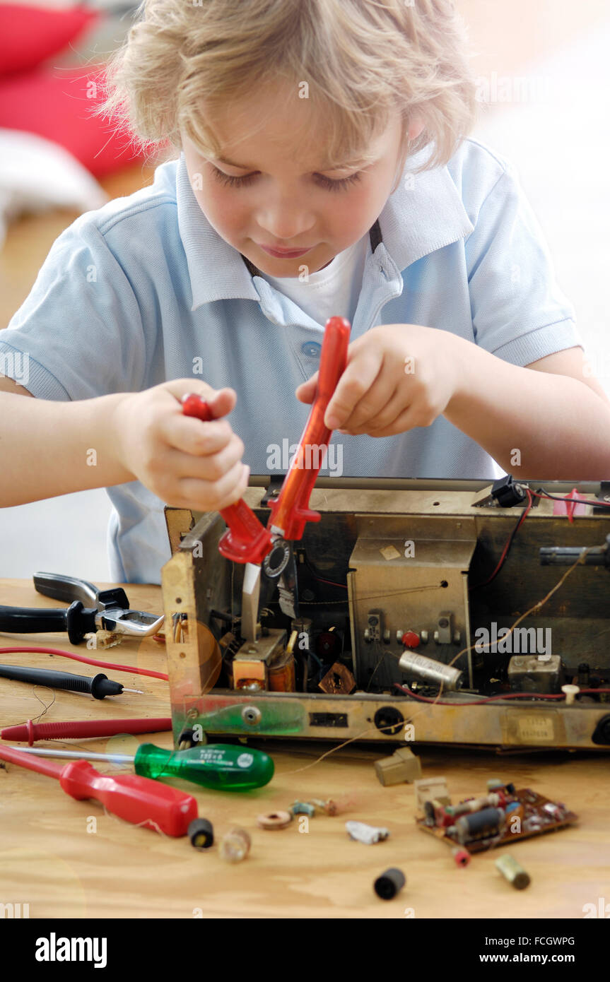 Little boy disassembling an old radio Stock Photo - Alamy